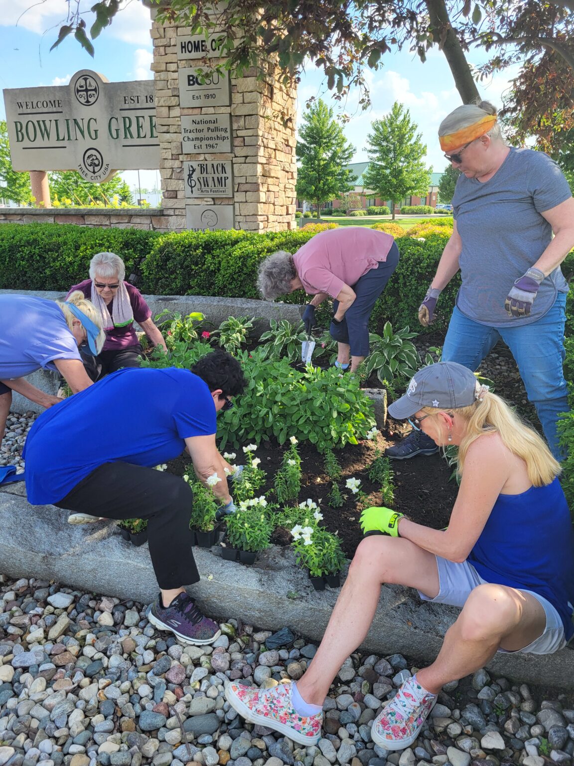 Women’s Club of BG Garden Group plants flowers at welcome sign at north ...